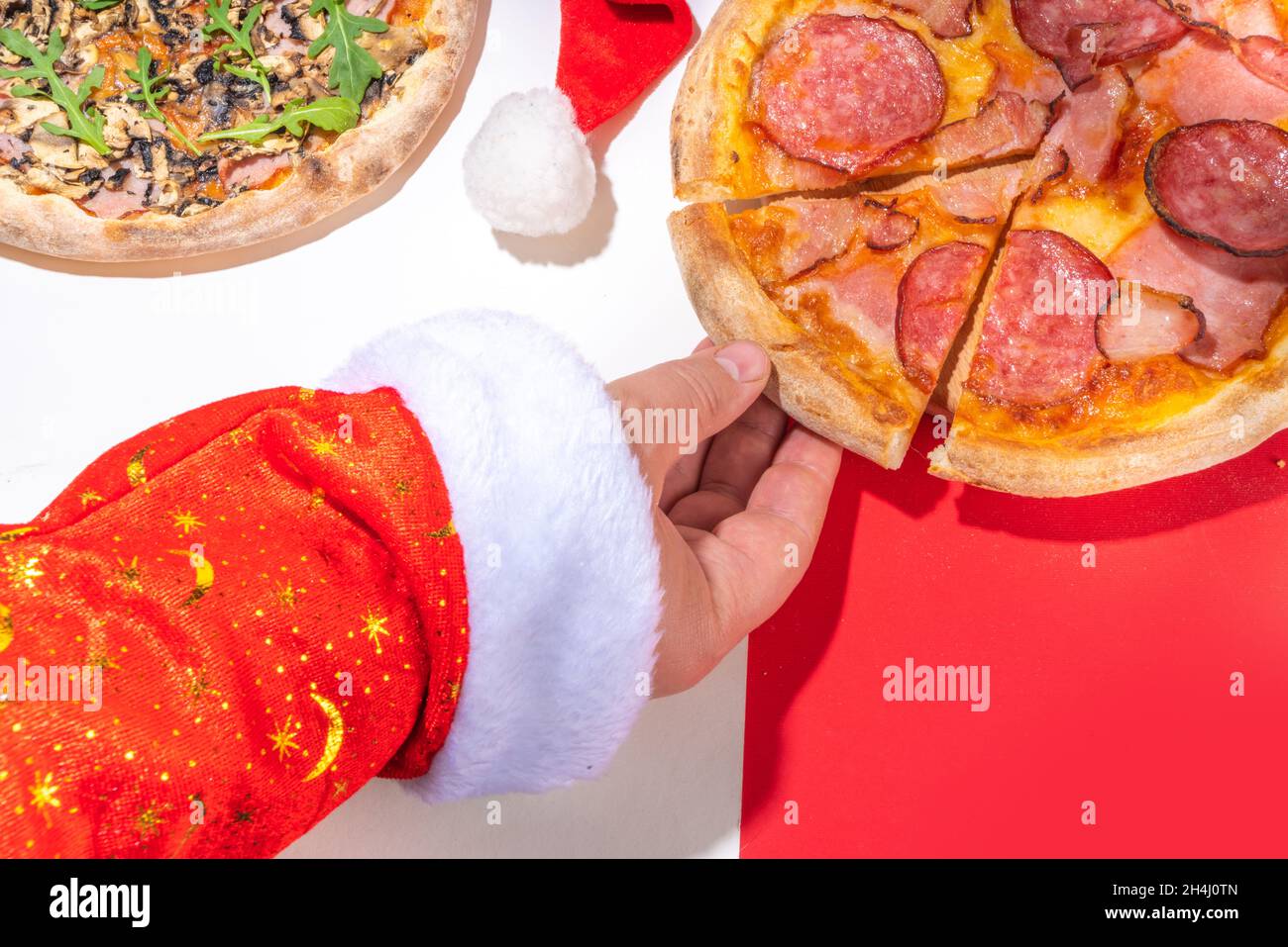 Pepperoni and mushrooms pizza, with Santa hands take pizza slice ...