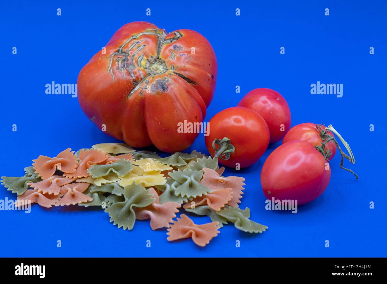 organically grown tomatoes and paste on a blue background Stock Photo - Alamy