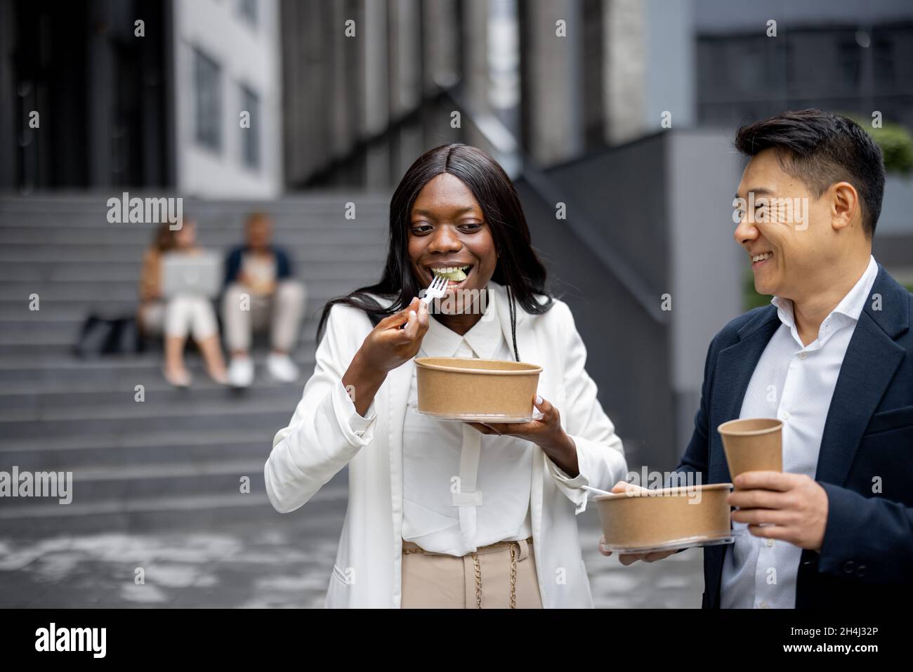 Business people eat on background of colleagues Stock Photo - Alamy