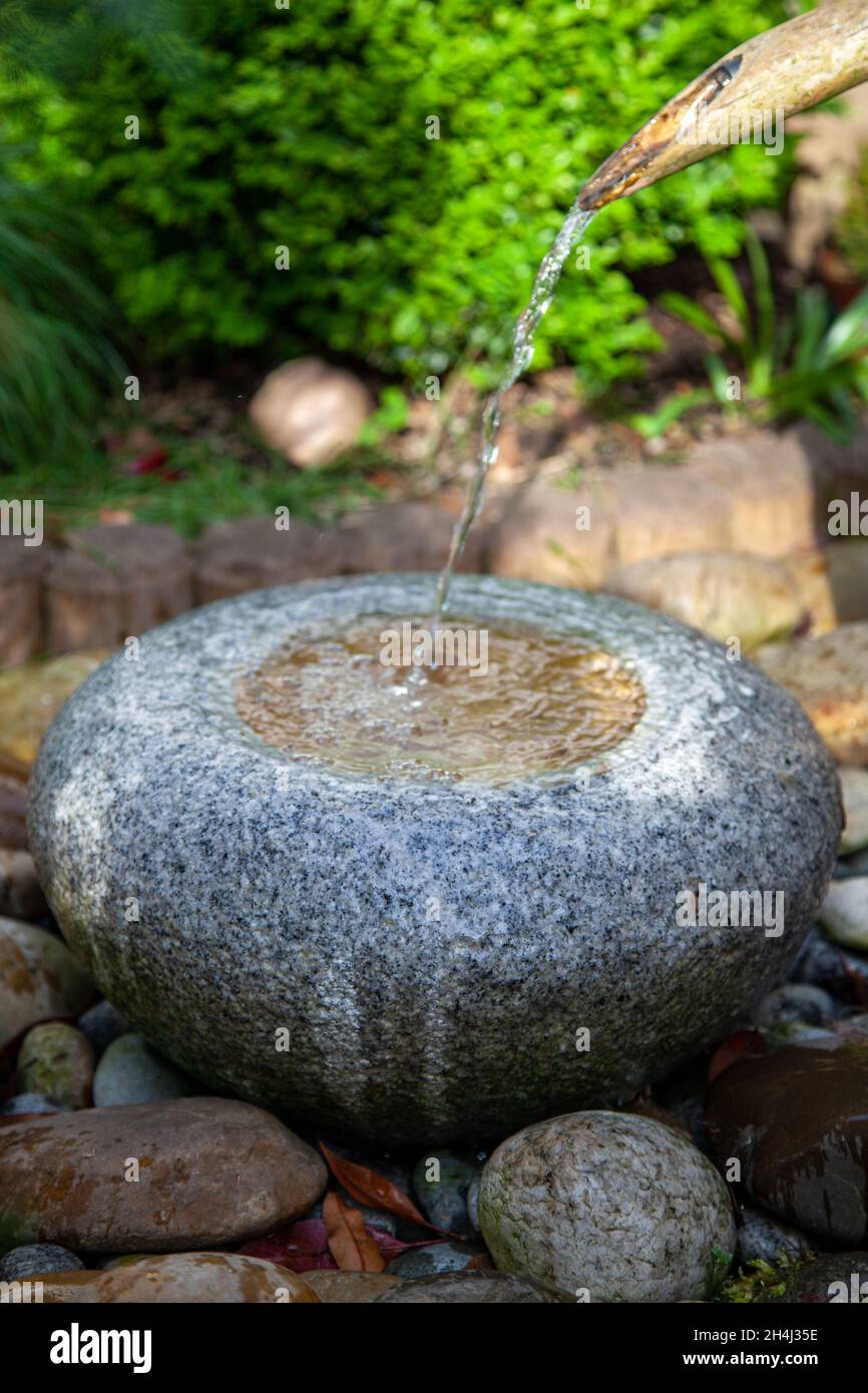 Zen fountain from the front made of granite stone that stands on large ...