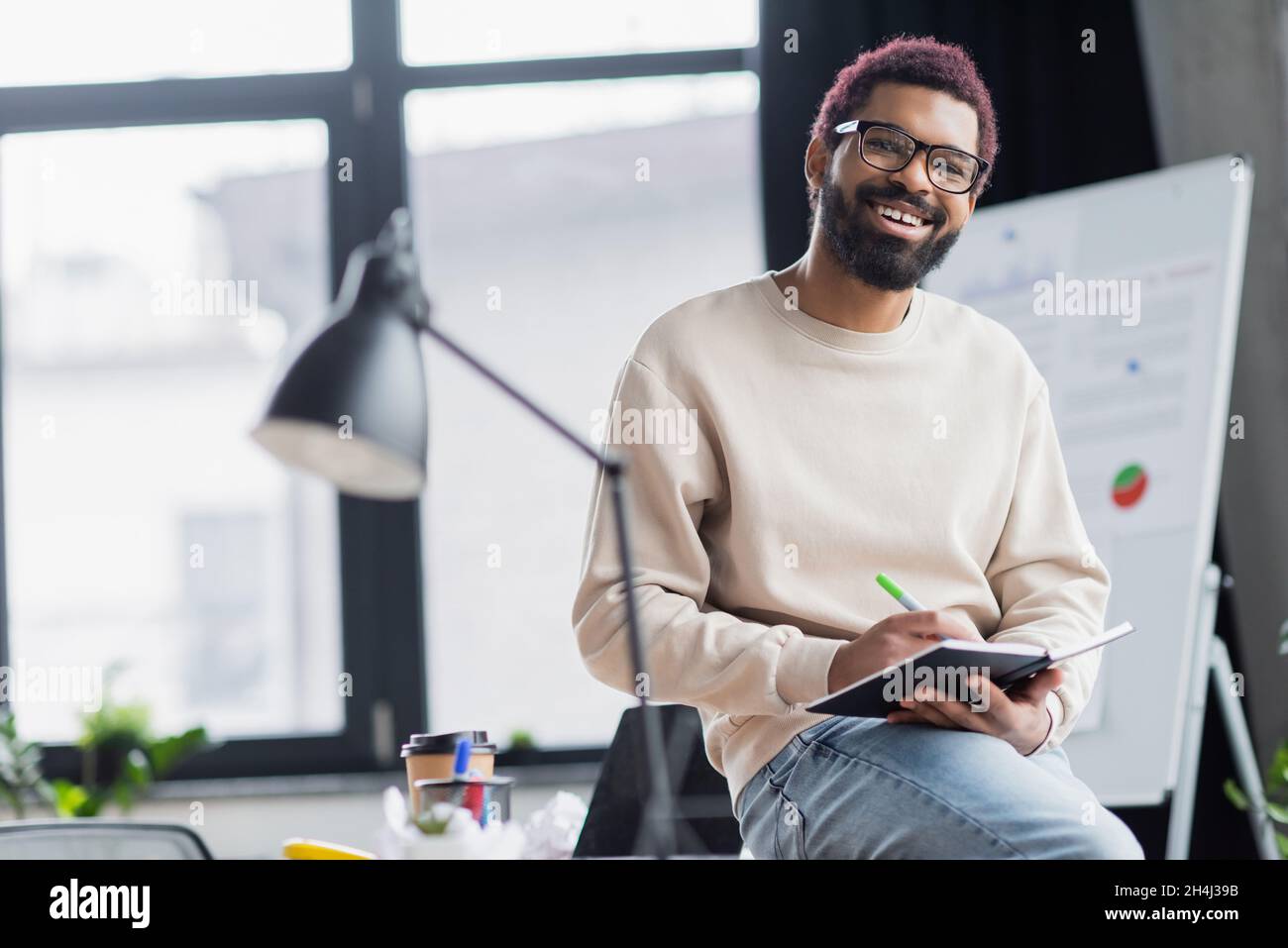 African businessman writing in office hi-res stock photography and ...