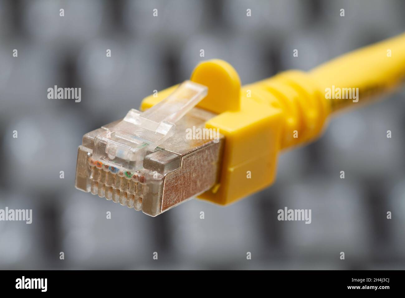 LAN network cable in yellow with a keyboard background Stock Photo - Alamy