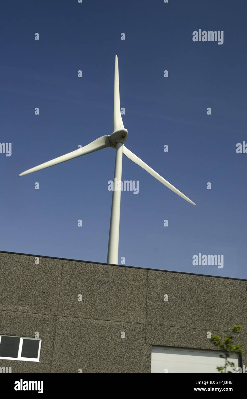 Wind turbine behind industrial building in Belgium Stock Photo - Alamy
