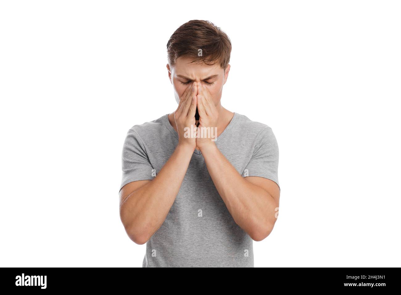 Sad millennial caucasian guy presses hands to nose and suffers from ...