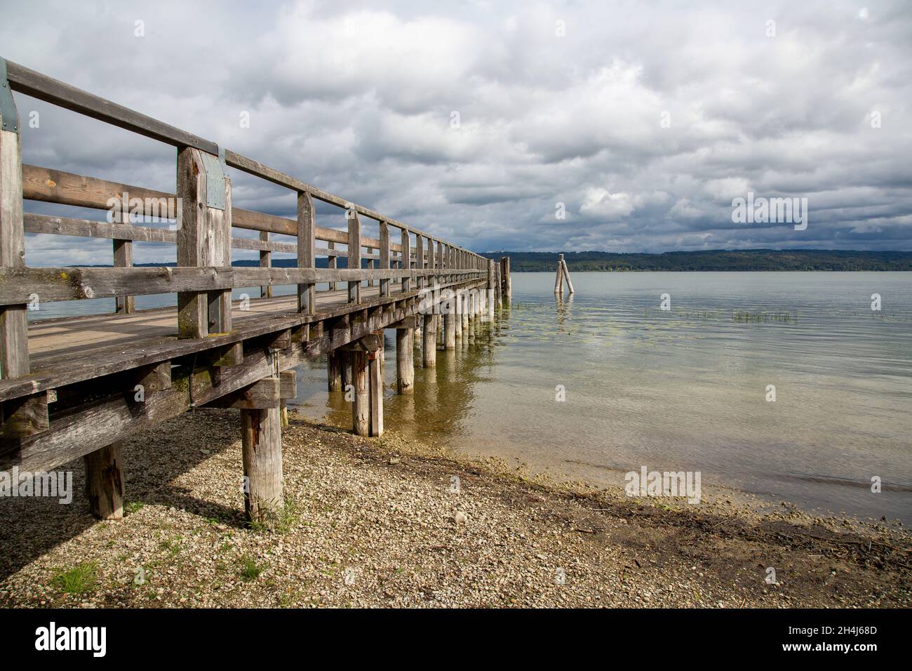 Wooden landing stage that extends far into a large lake in Bavaria ...