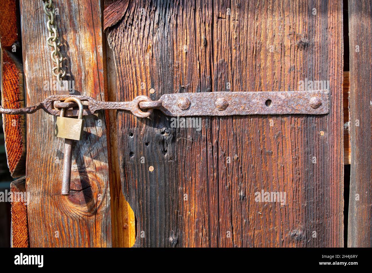 antique gate of a wooden slider with bolt and padlock Stock Photo - Alamy