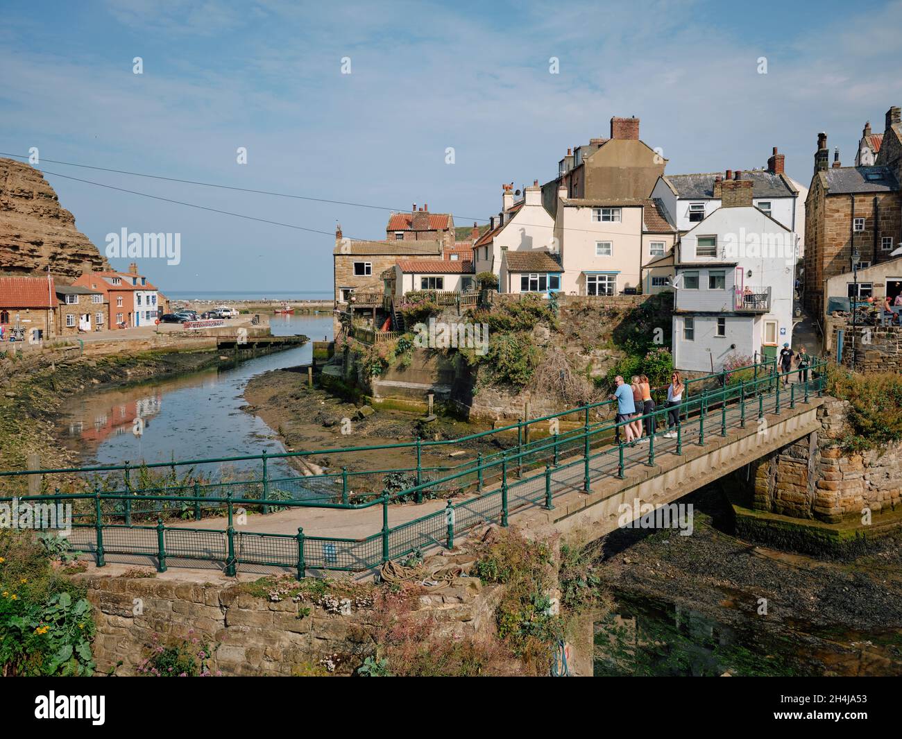 Tourists enjoying Staithes harbour and beck at low tide in the popular ...