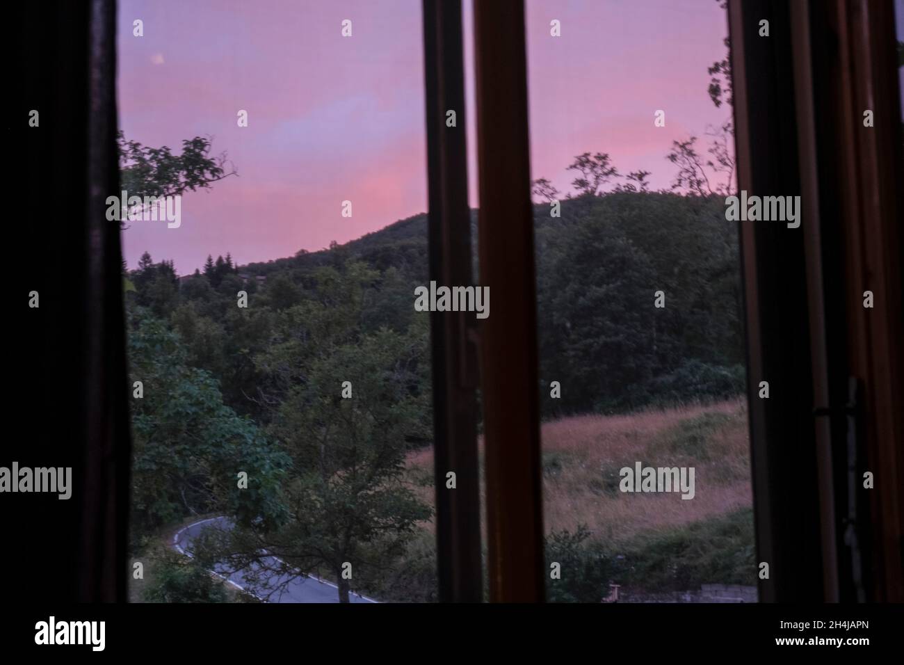 window view from a room to an evening sunset sky and trees. Indoor view ...
