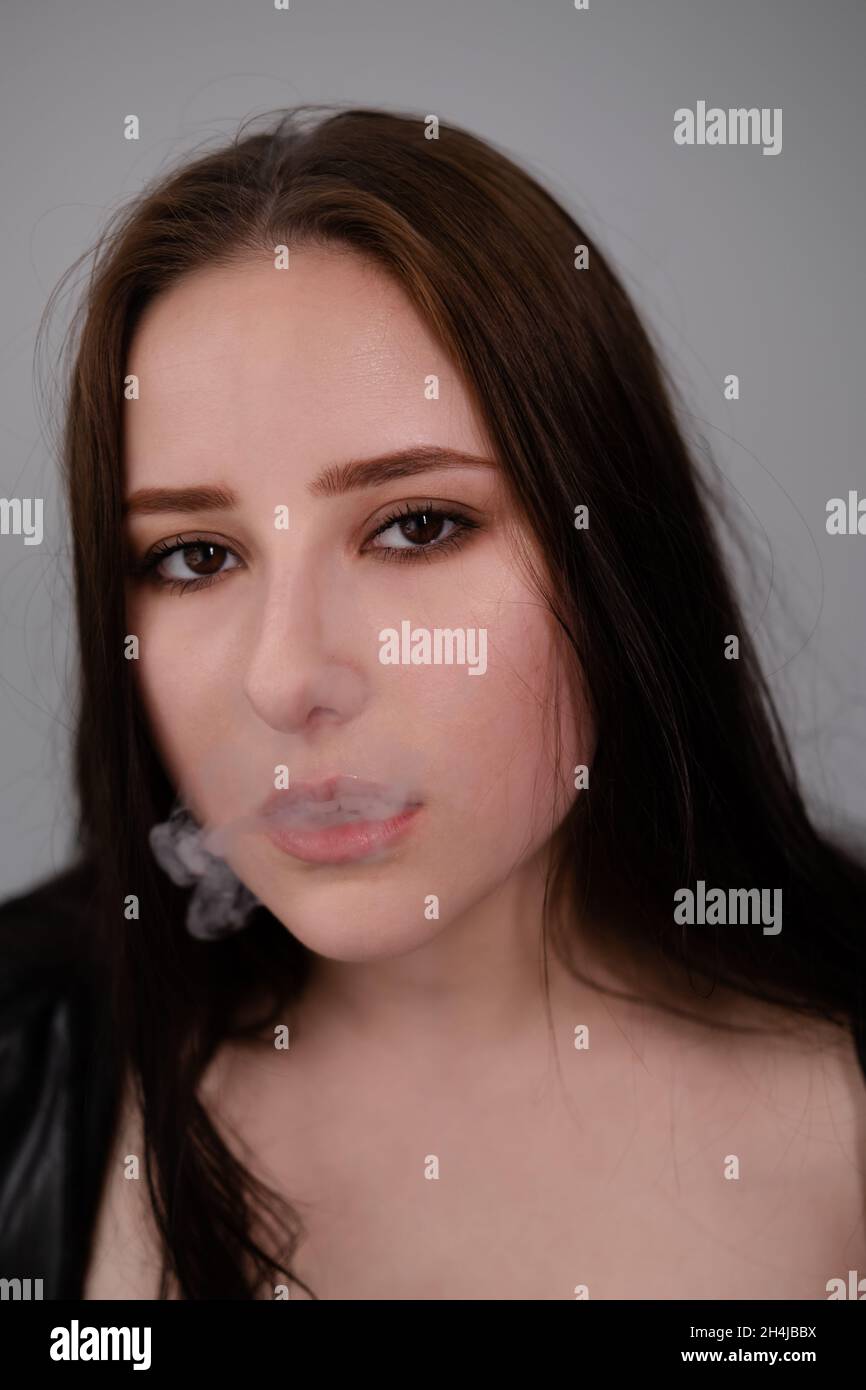 Young female exhaling cigarette smoke hi-res stock photography and ...