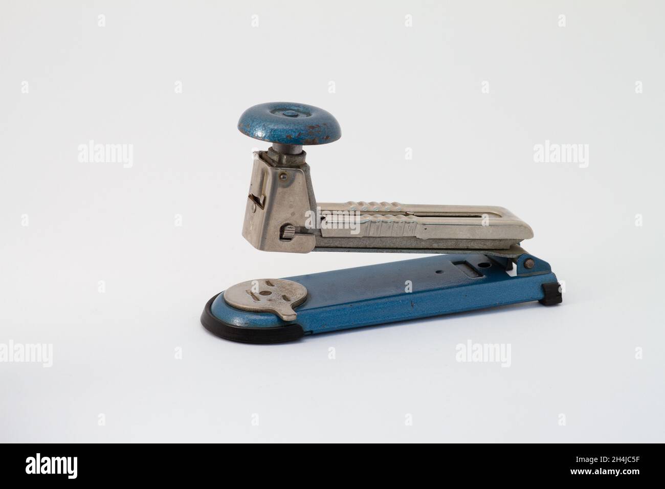 antique paper stapler in silver and blue. Space and white background ...