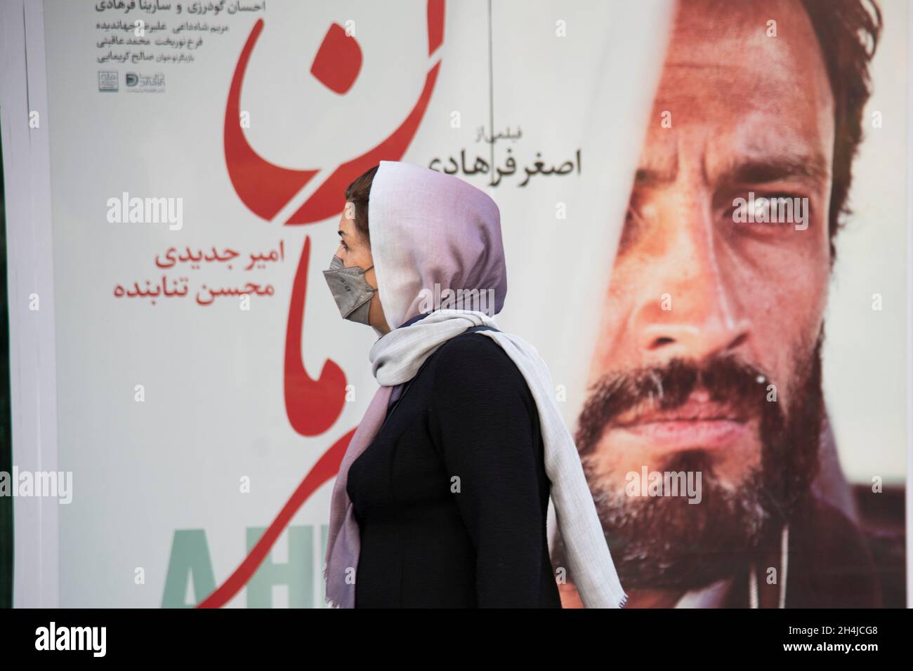 Tehran, Iran. 02nd Nov, 2021. A woman walks past "A Hero" movie poster ...