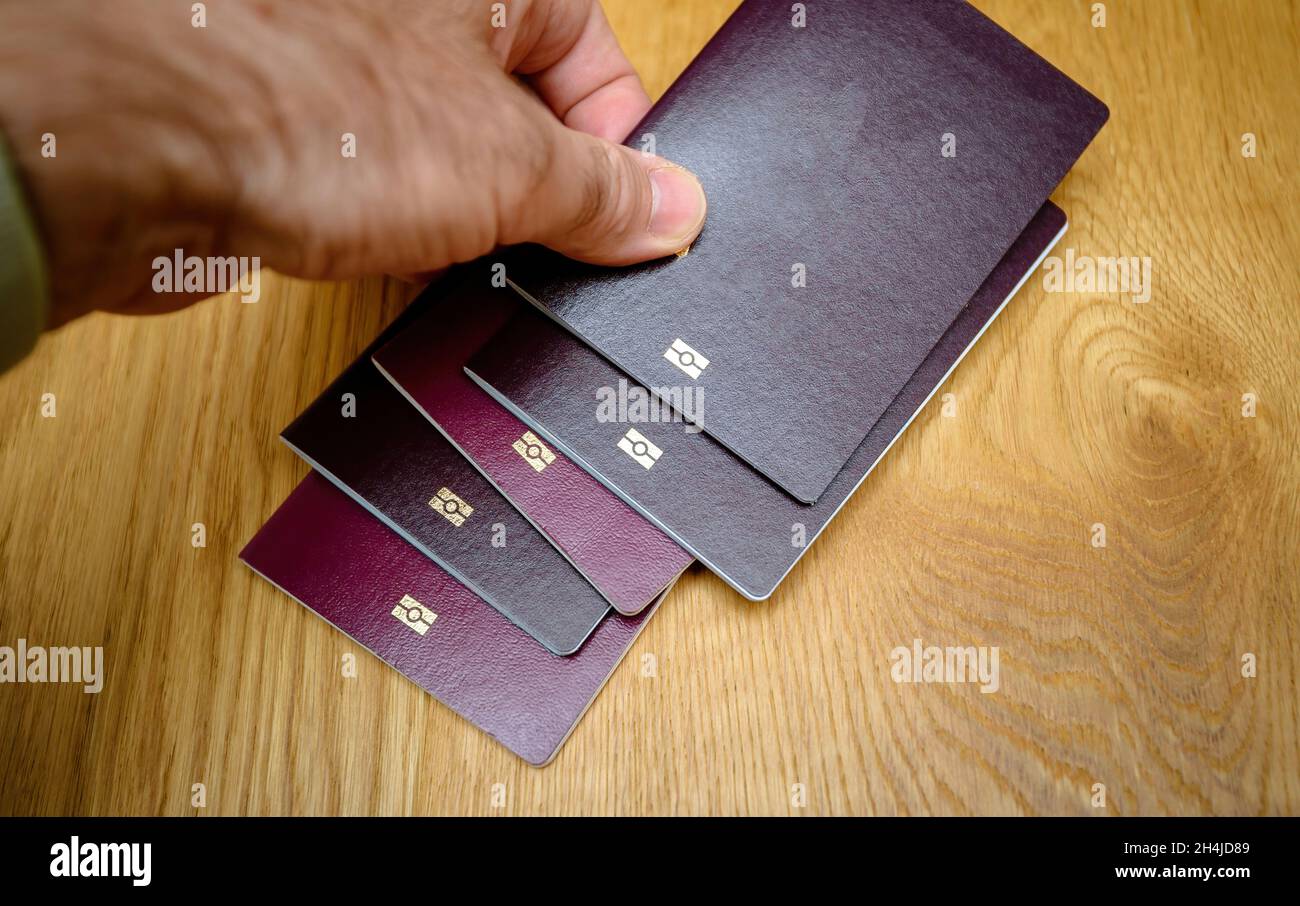 Closeup of male hand arranging multiple biometric passports with ...