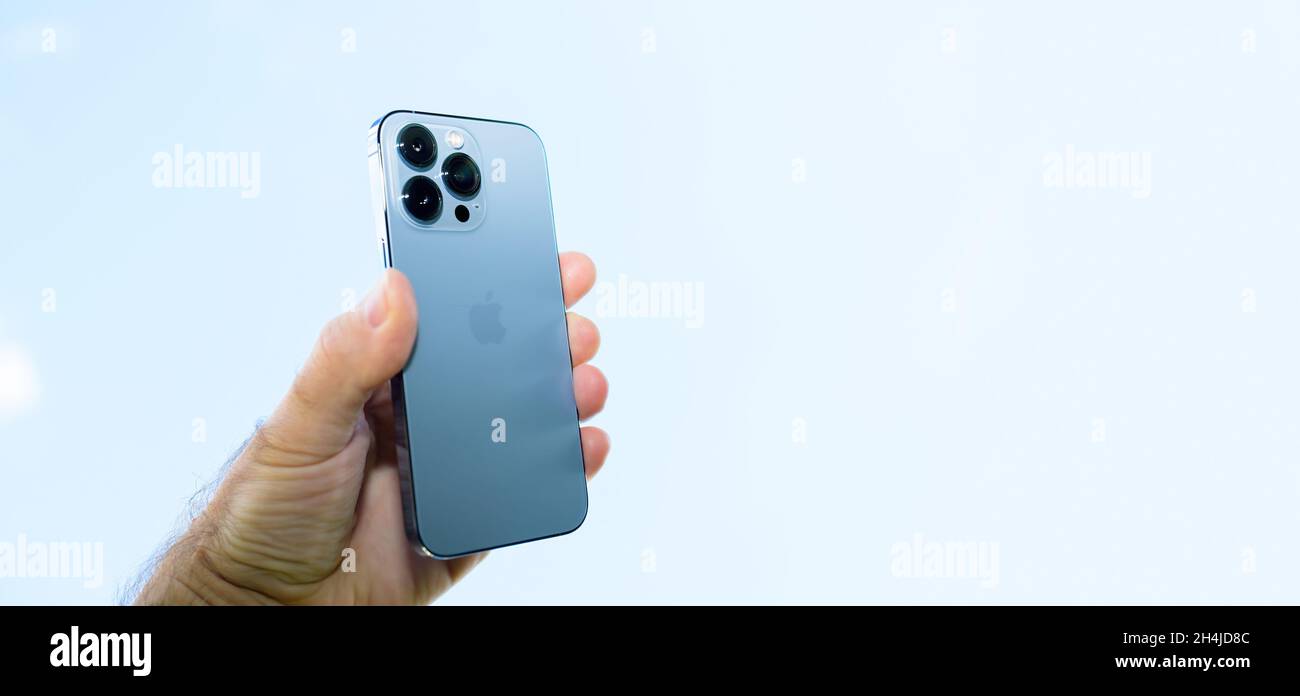 Male hand holding latest Apple Computers iPhone 13 pro with all three ...