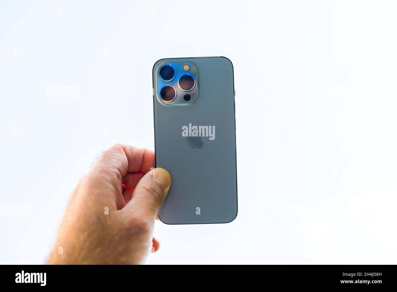 Male hand holding latest iPhone 13 Pro Professional isolated on white ...