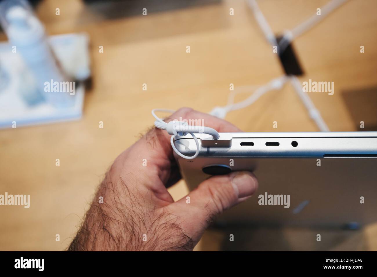 Male hand checking the new mag safe charging port of Apple Computers ...