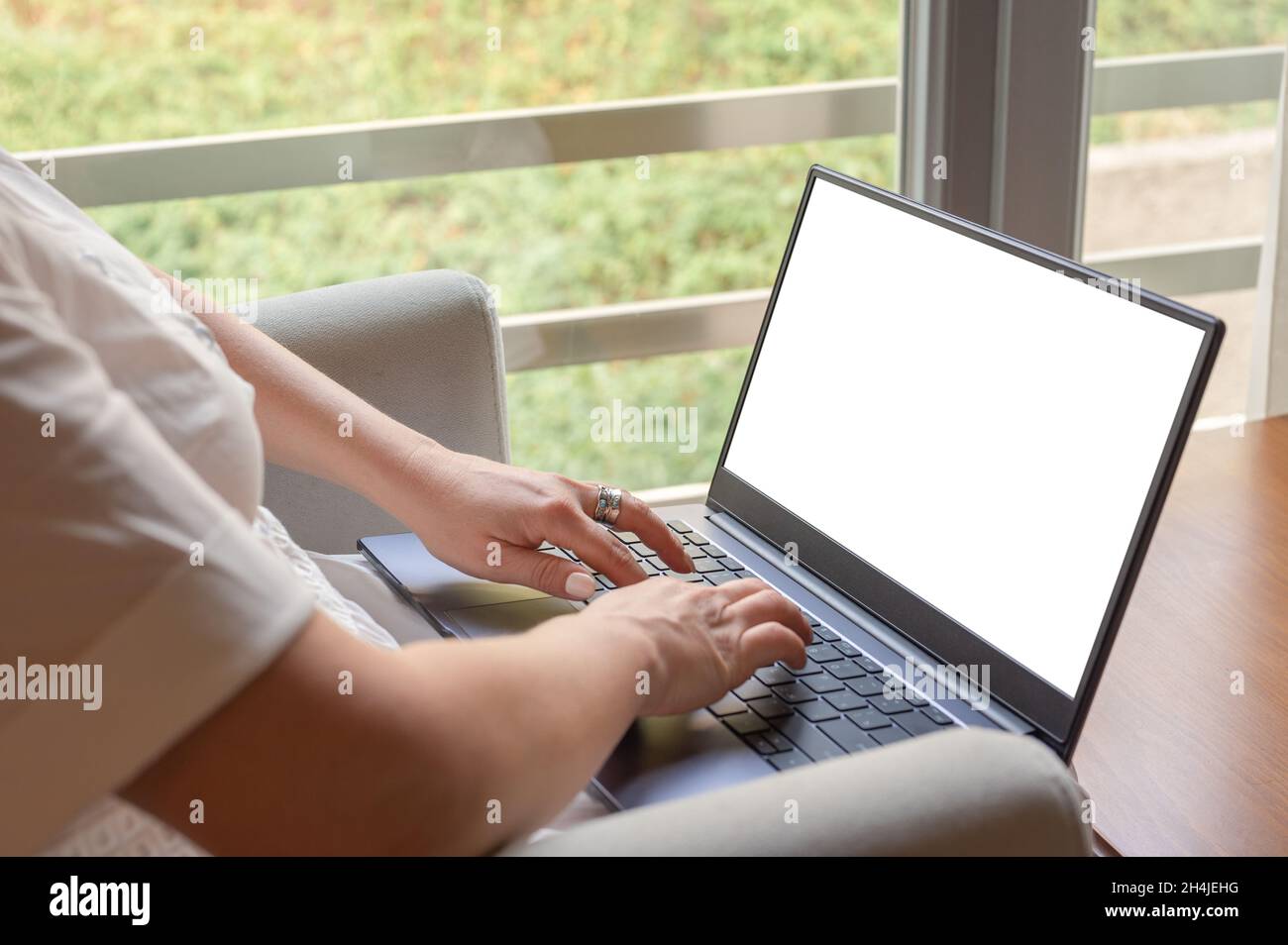 Woman hands using computer mockup laptop with blank white screen at ...