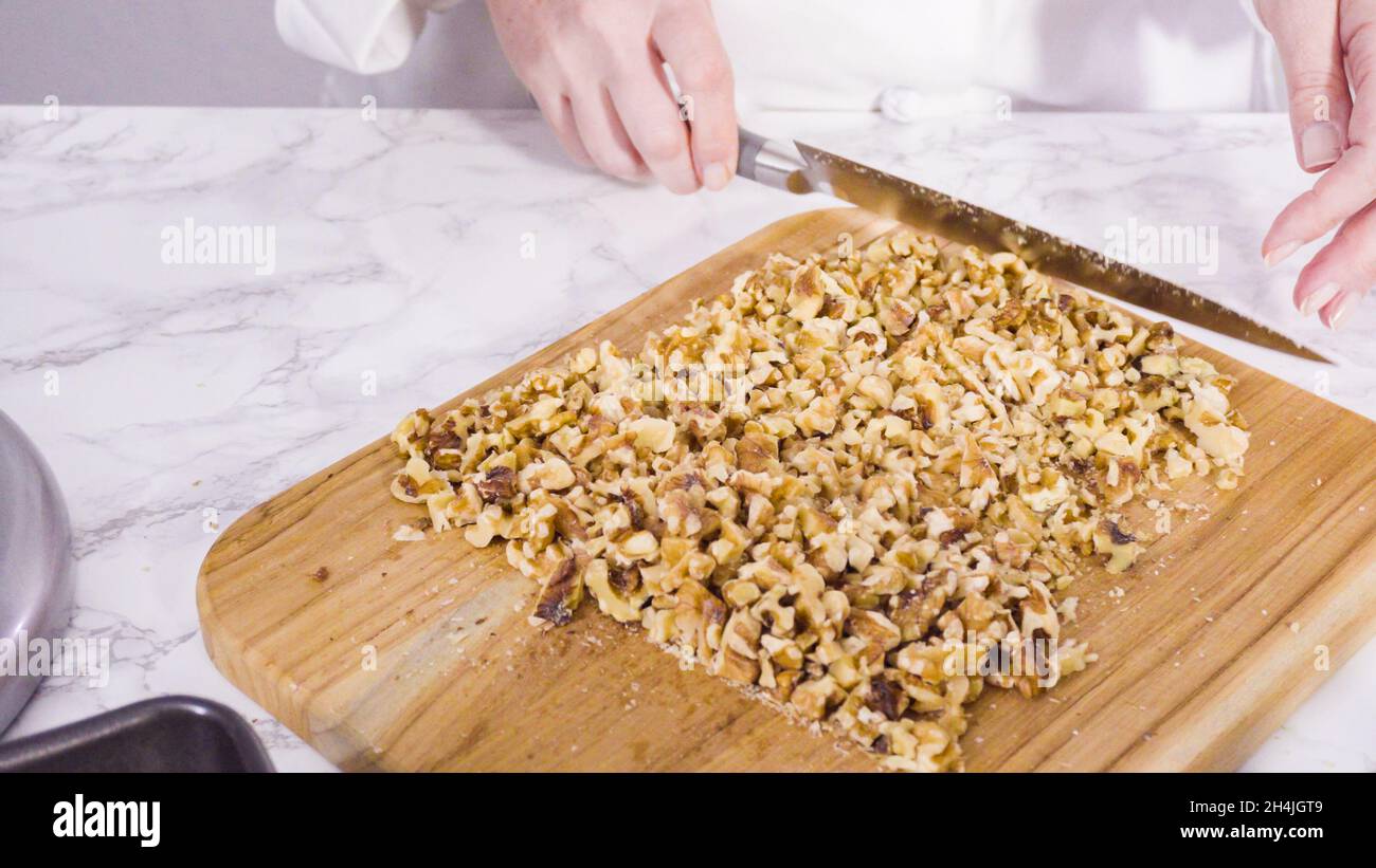 Step by step. Chopping walnuts with kitchen knife on a wood cutting ...