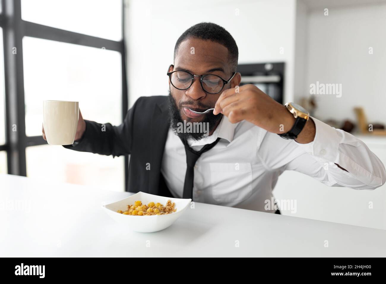 Black man rushing to work eating cereal at home Stock Photo - Alamy