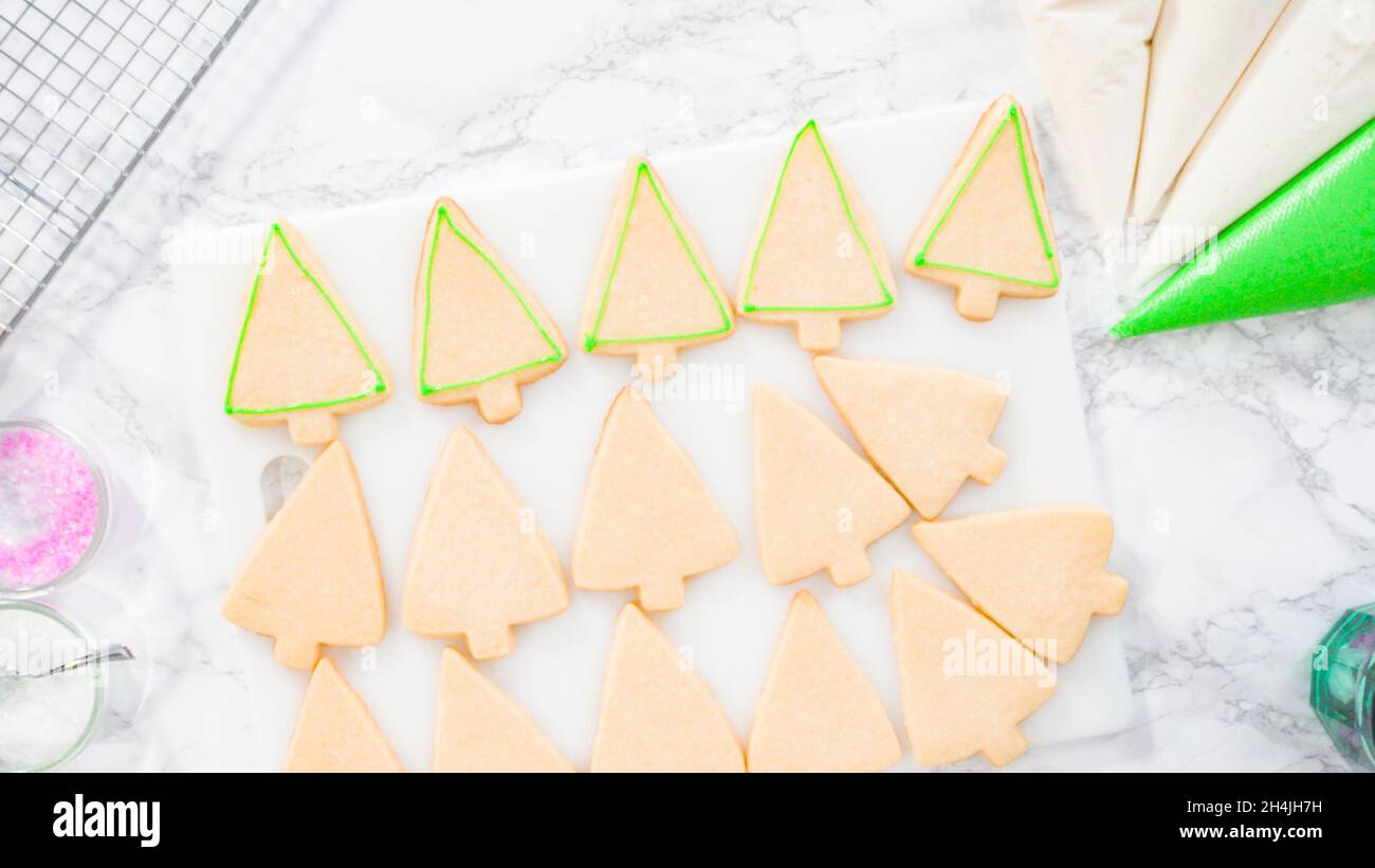 Flat lay. Stp by step. Icing Christmas tree-shaped sugar cookies with ...