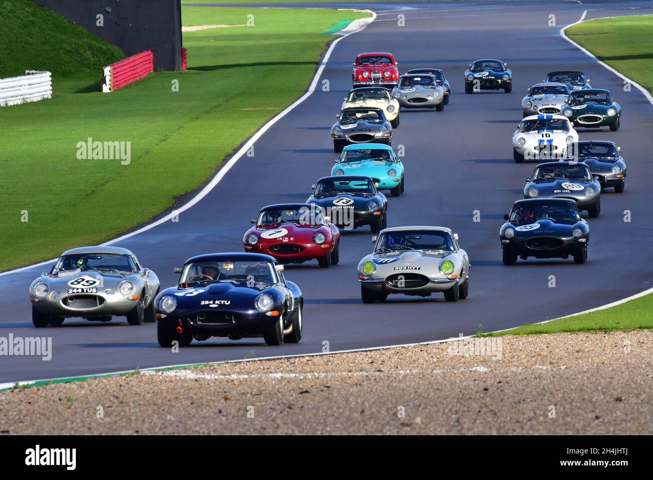 A grid of twenty Jaguars head down the Hanger Straight on the green ...