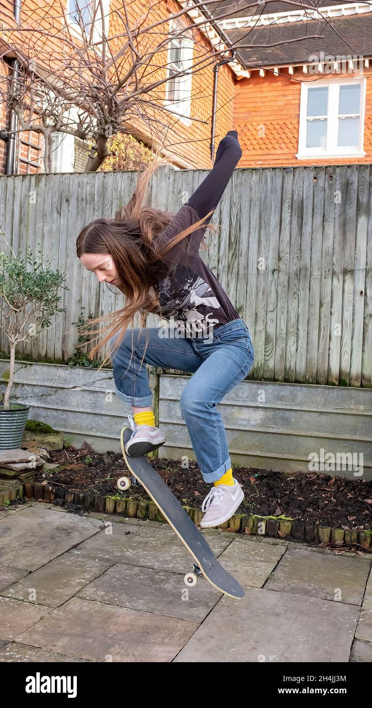 Teenage girl, jumping on a skateboard Stock Photo - Alamy