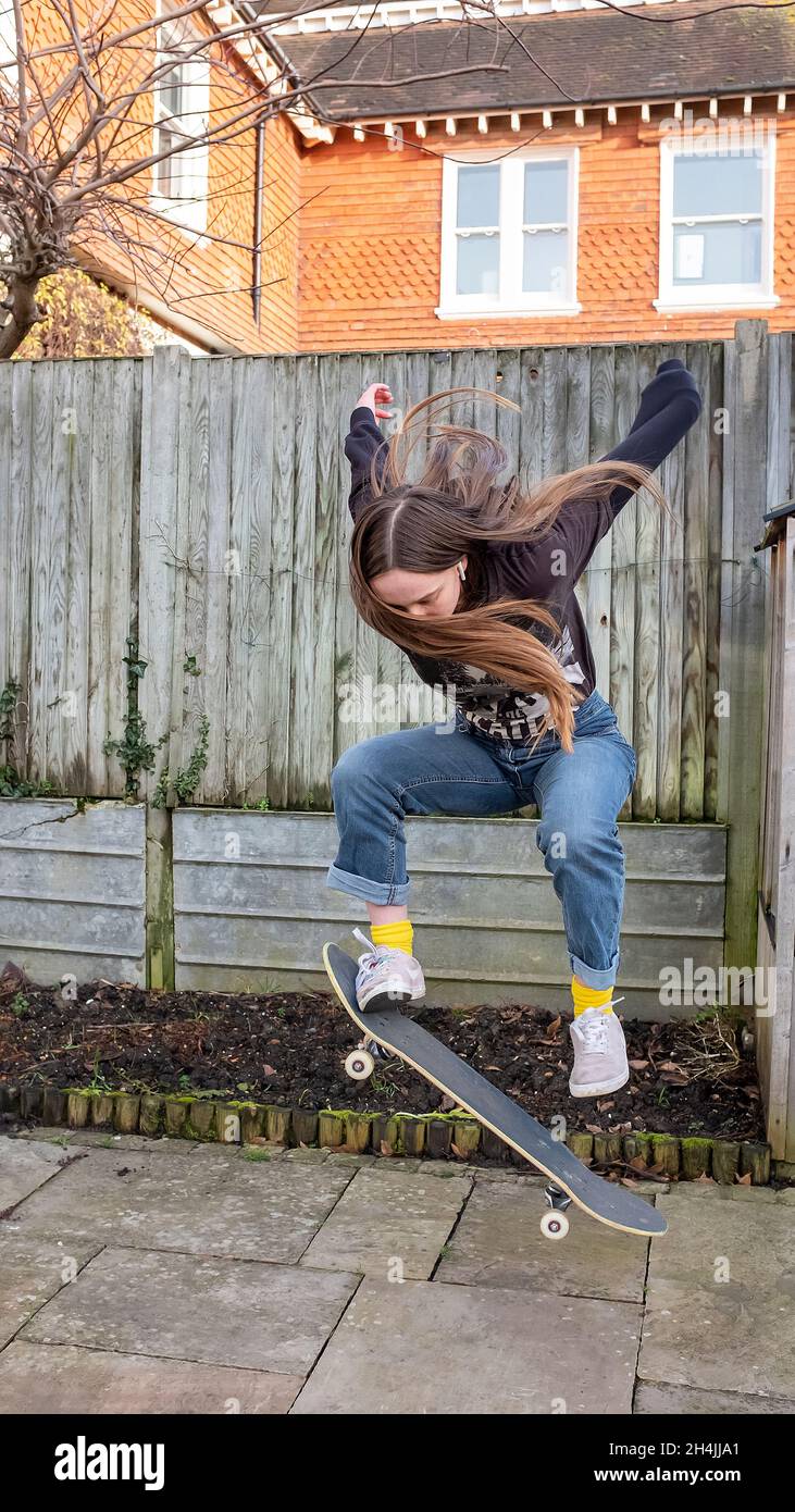Teenage girl, jumping on a skateboard Stock Photo - Alamy