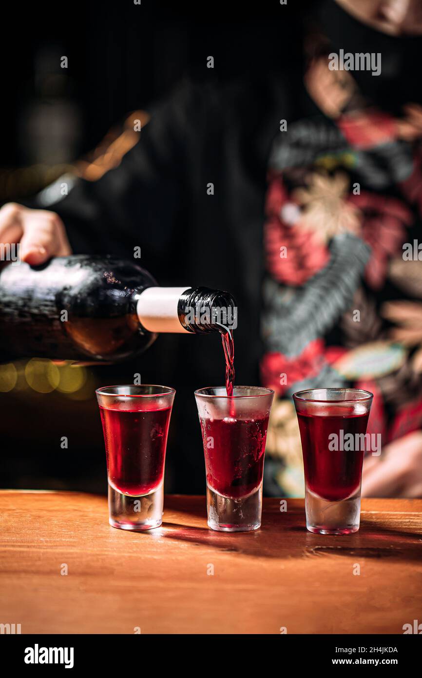 Bartender pouring red sweet liqueur Stock Photo - Alamy