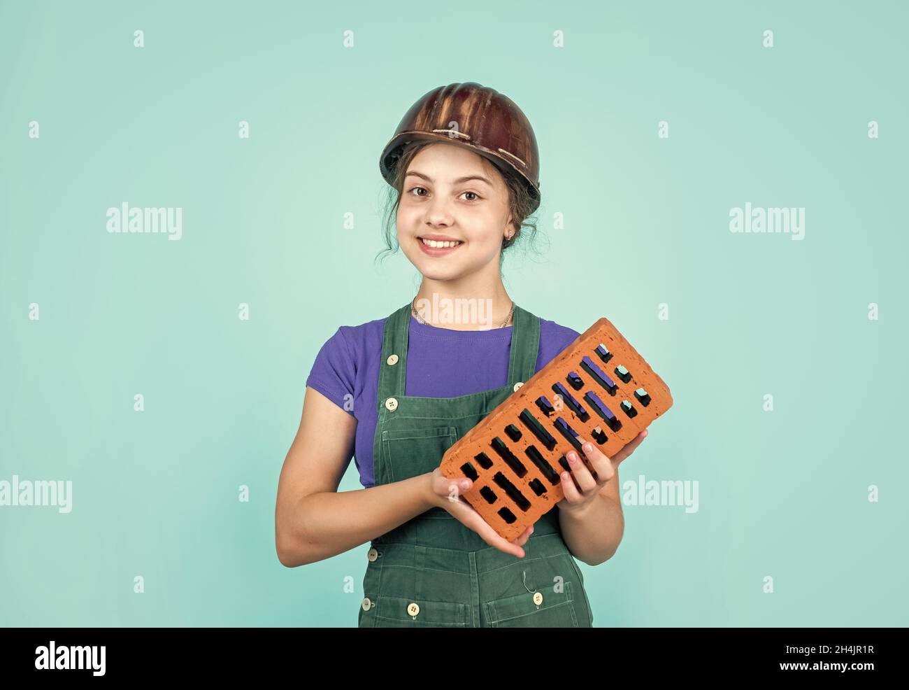 Child in uniform working around brick wall. labour day concept. Little ...