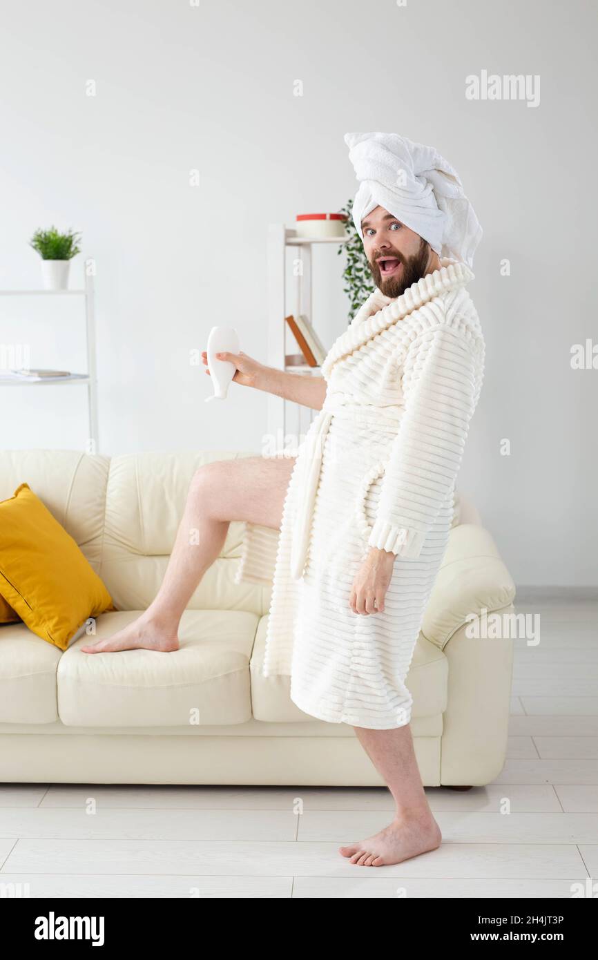 Funny portrait of handsome beautiful guy in towel and bathrobe holding ...
