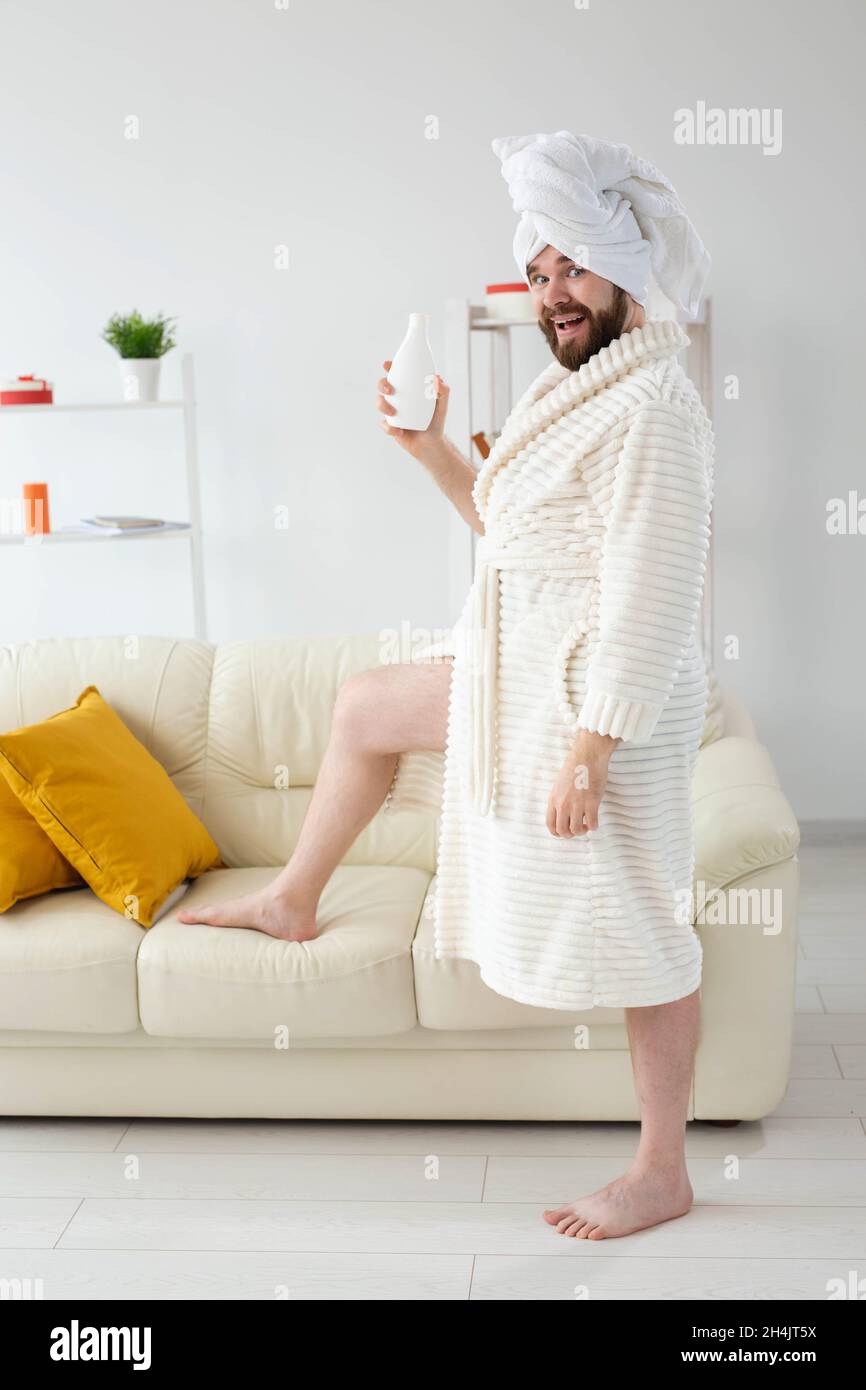 Funny portrait of handsome beautiful guy in towel and bathrobe holding ...