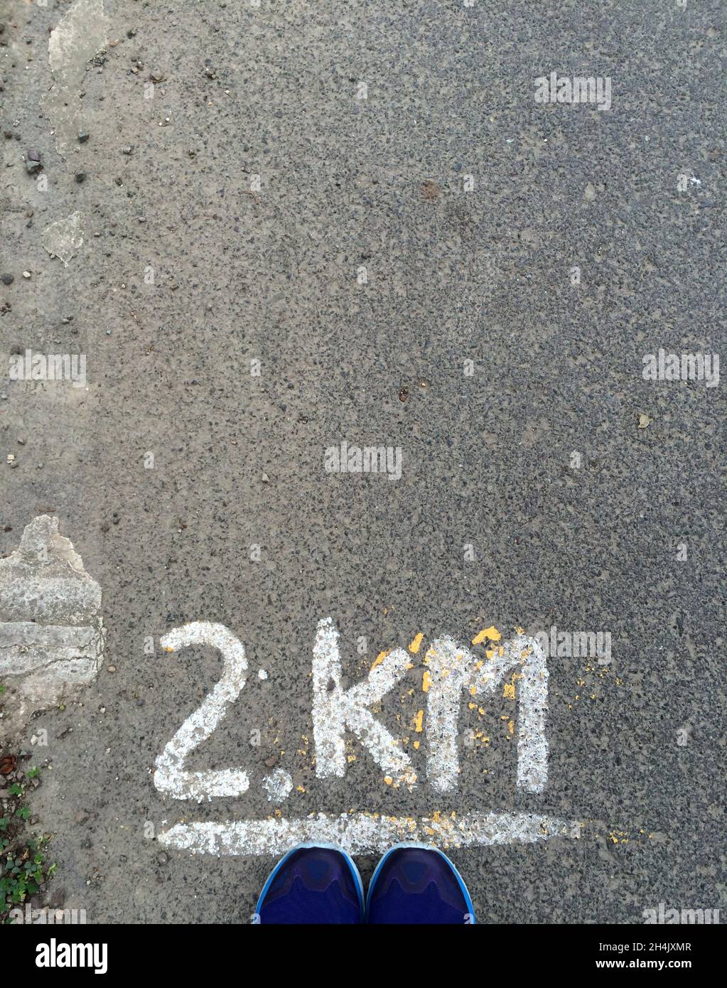 Overhead view of a runner standing by a 2km road marking, Malaysia ...
