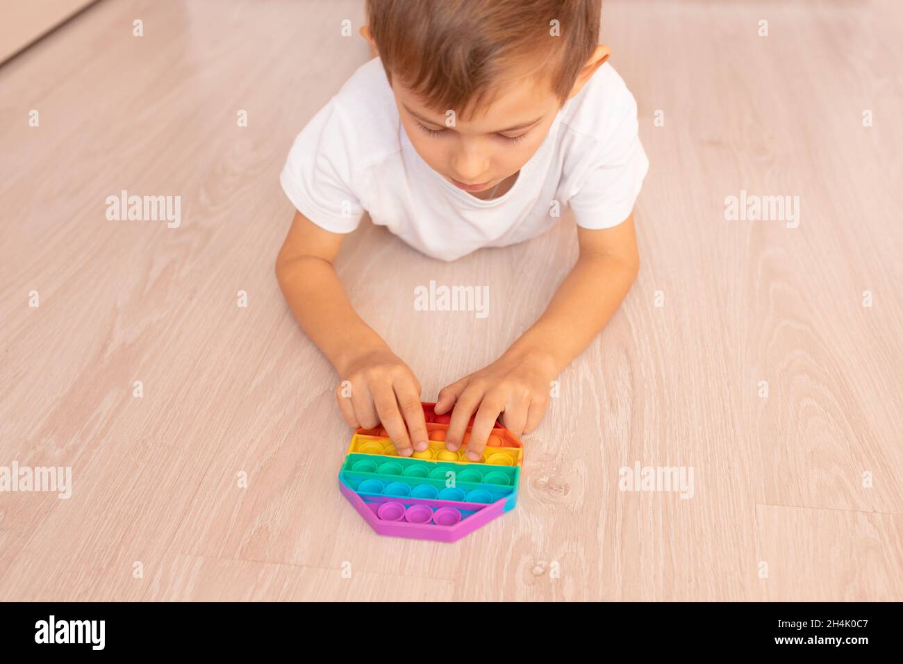 A child with a colorful pop it game. Anti-stress. Popular Relaxing ...