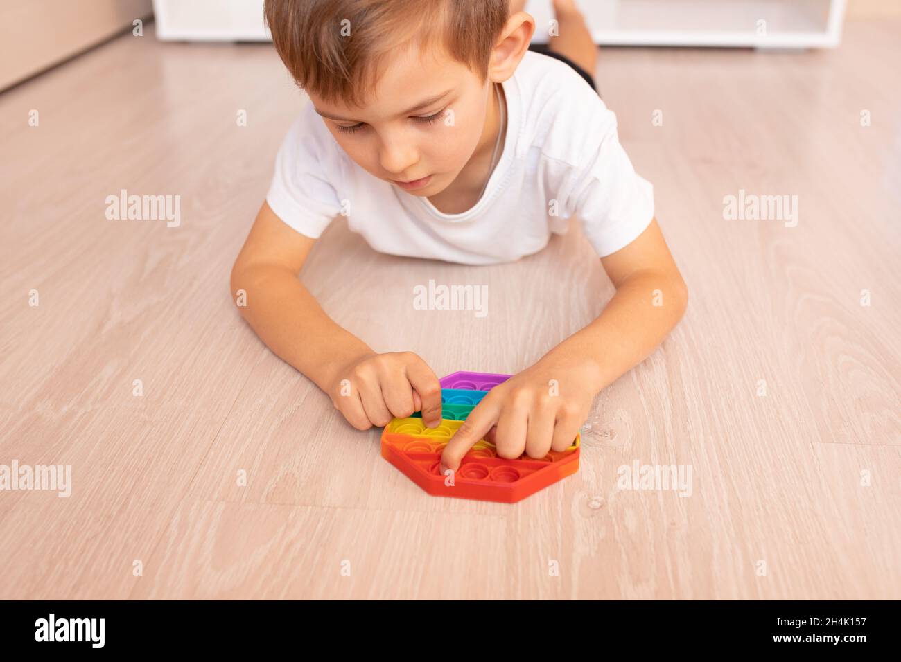 A child with a colorful pop it game. Anti-stress. Popular Relaxing ...