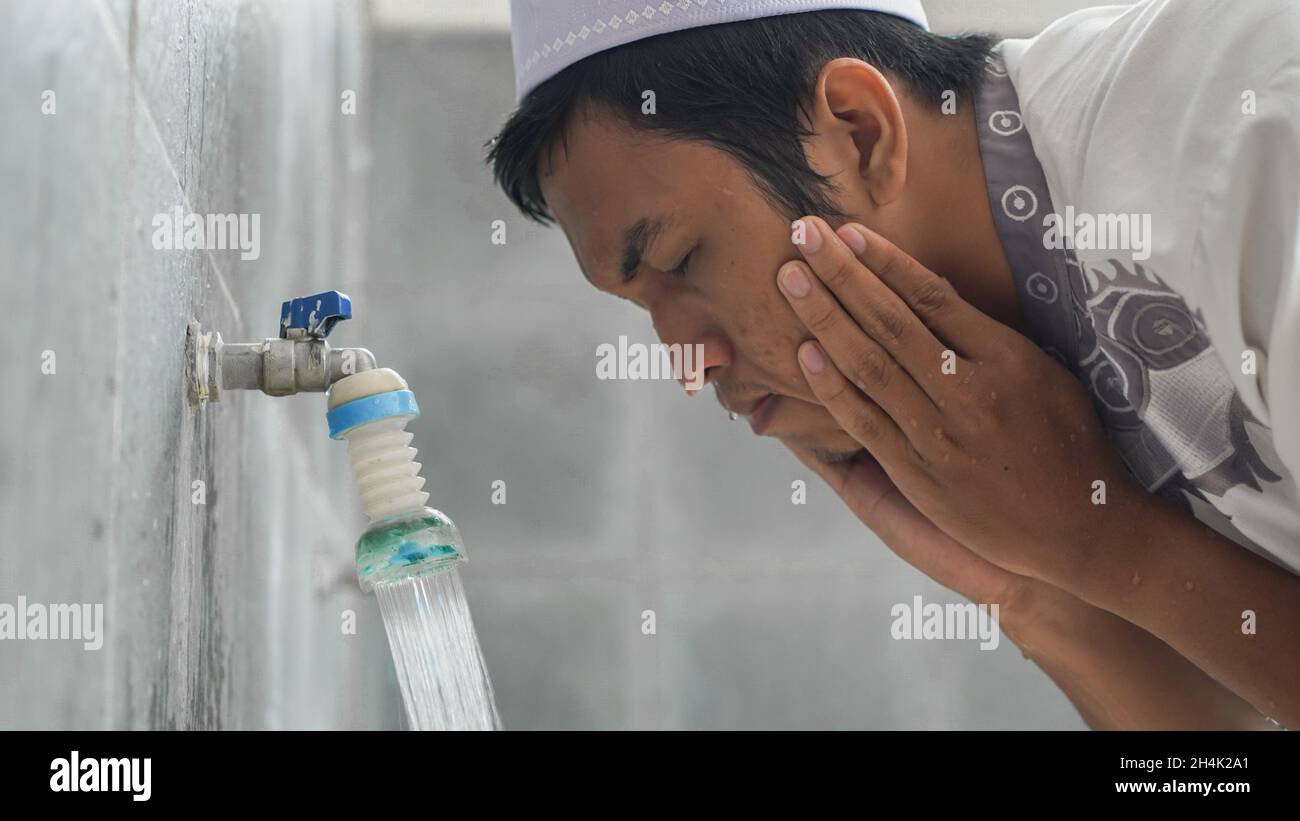 Close-up portrait of a man taking ablutions before prayer at a mosque ...