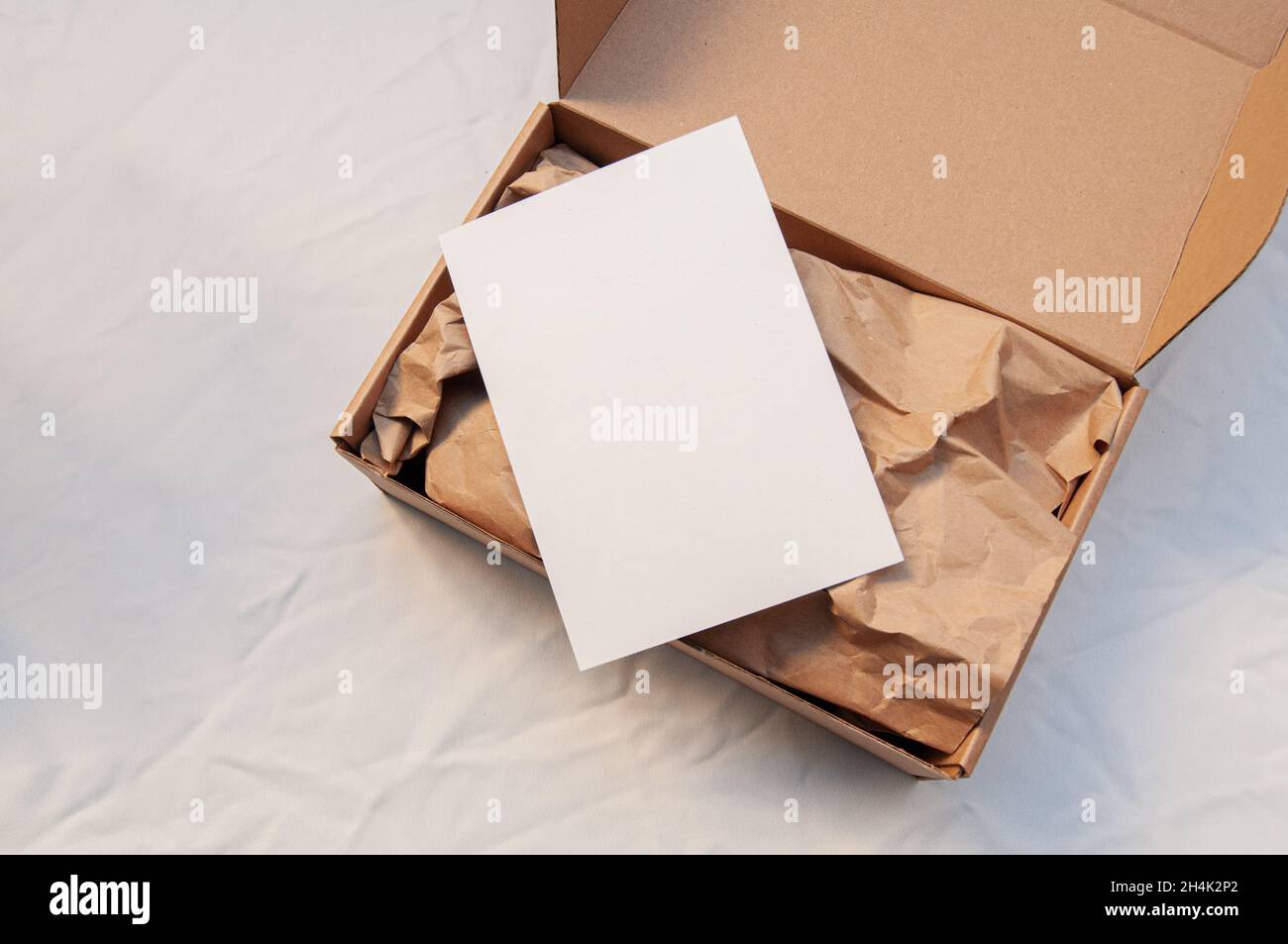 Overhead view of a blank envelope on an open cardboard box Stock Photo ...
