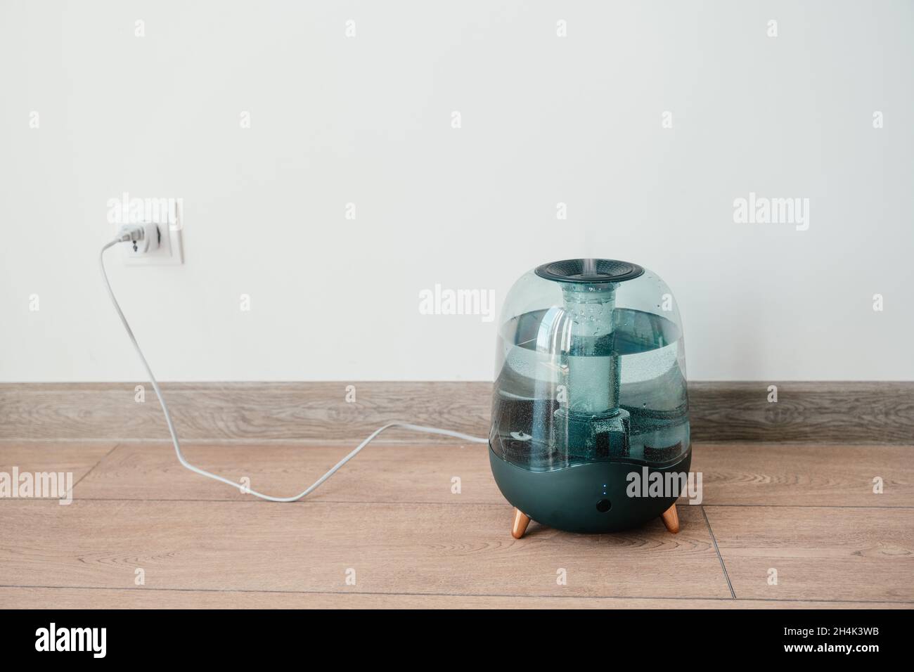 Modern air humidifier on a white wall background. Humidifier spreading ...
