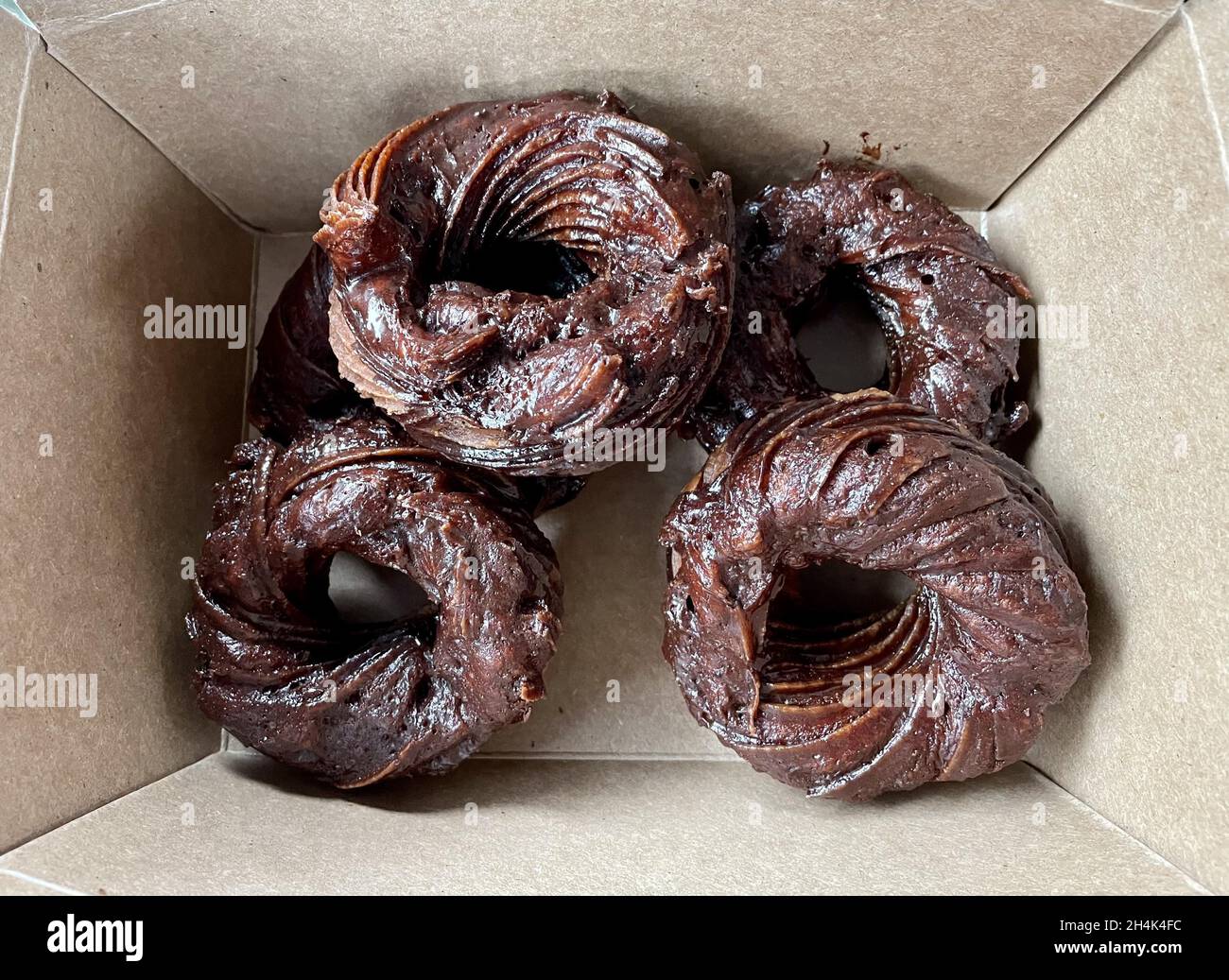 Overhead view of five chocolate doughnuts in a cardboard box Stock ...