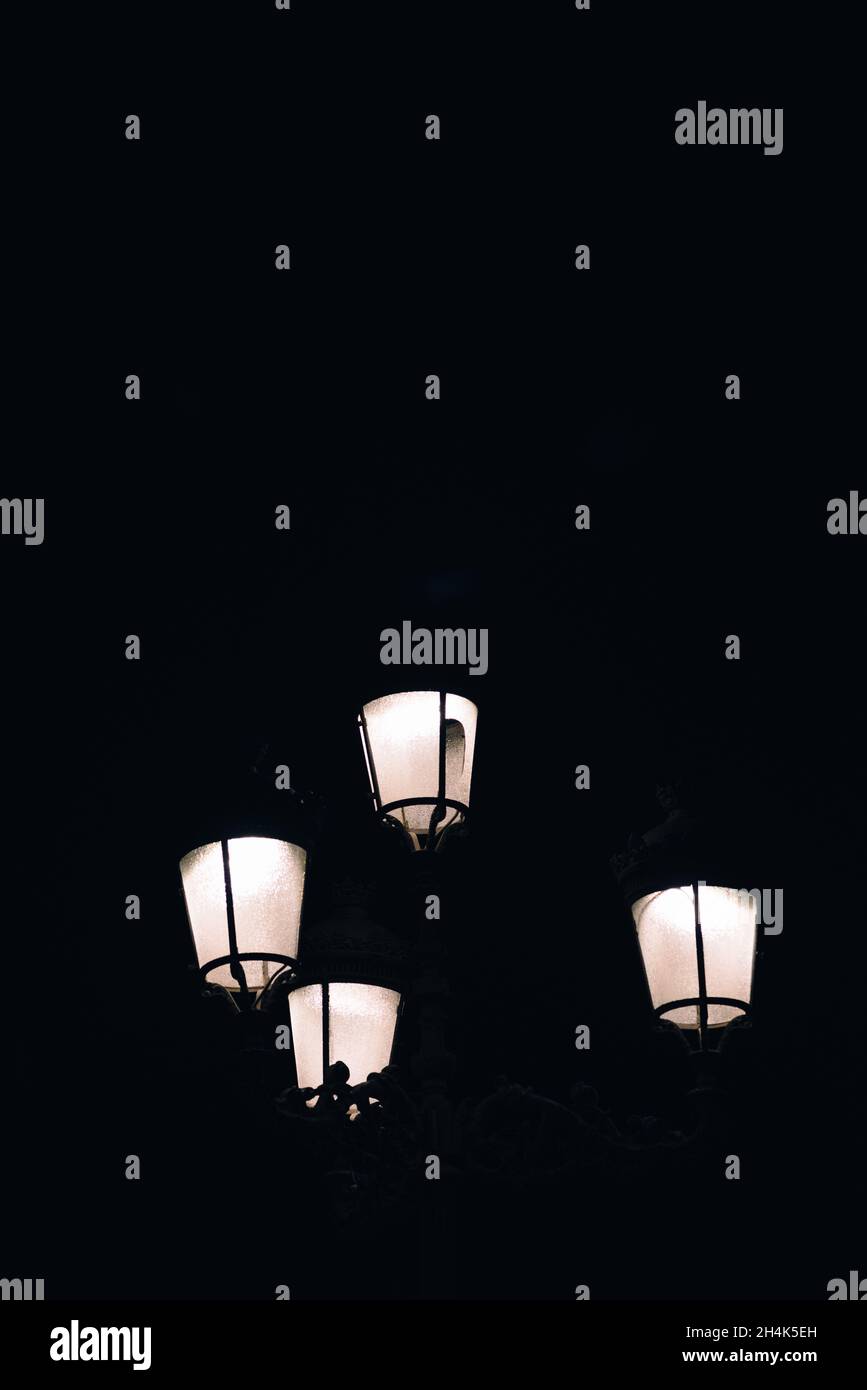 Vertical shot of four street lights on a steel post at night Stock ...