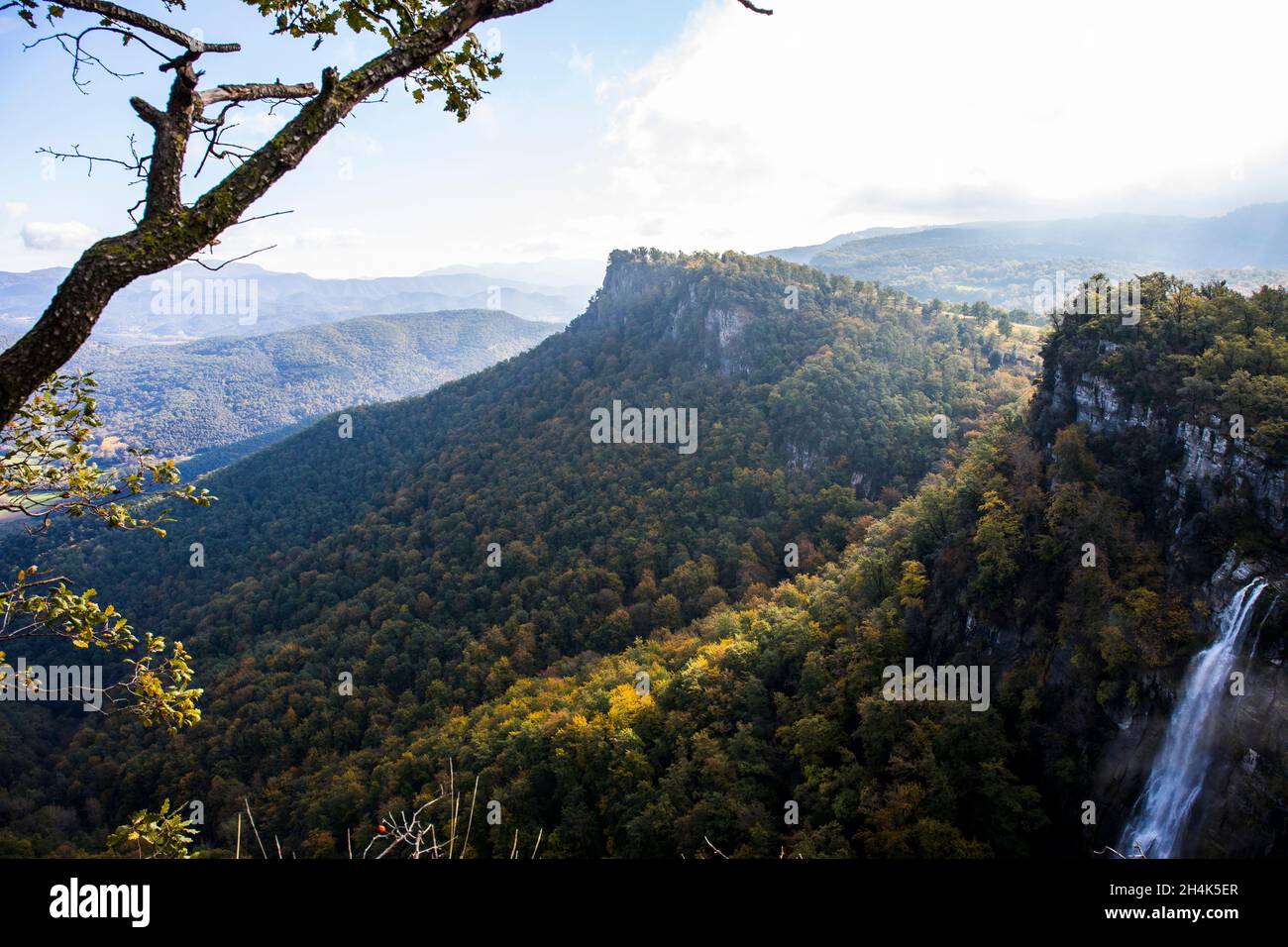 Lush forest covered mountains and Salt De Coromina waterfall in autumn ...