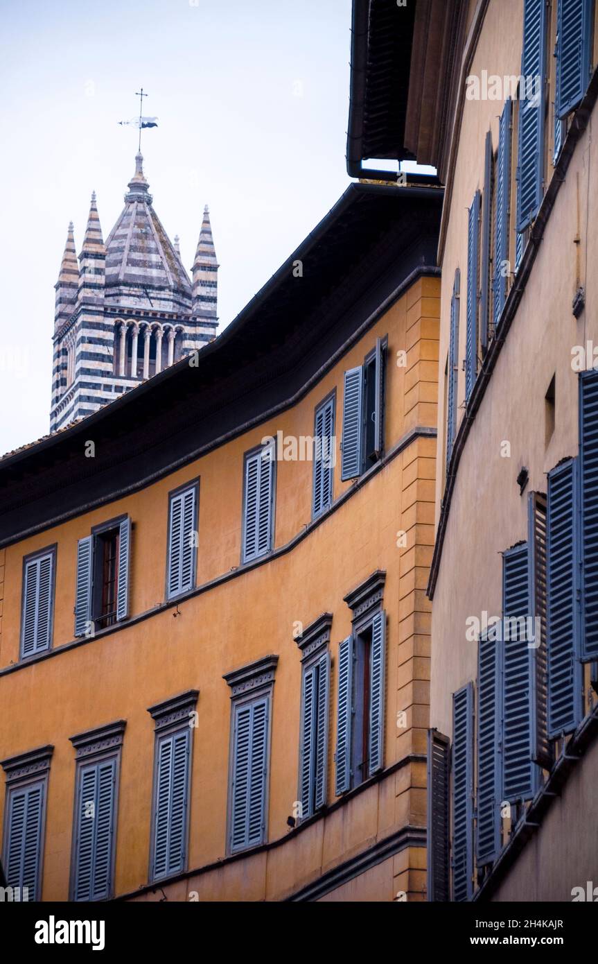Striped bell tower of Siena Cathedral and curving facades of its ...
