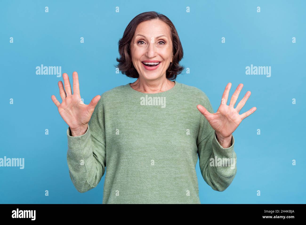 Photo of aged white hair hooray lady wear green jumper isolated on blue ...