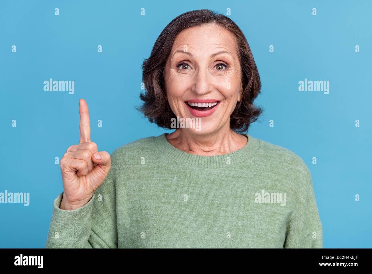 Photo of elder grey hair funky lady index up wear green jumper isolated ...