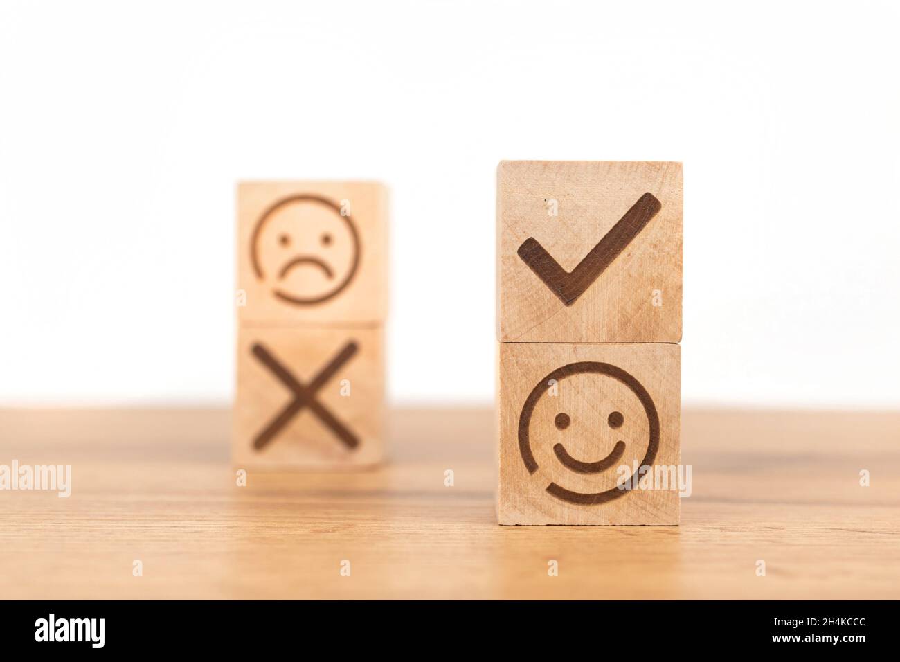 Customer choose smiley face and blurred sad face icon on a wooden cubes ...