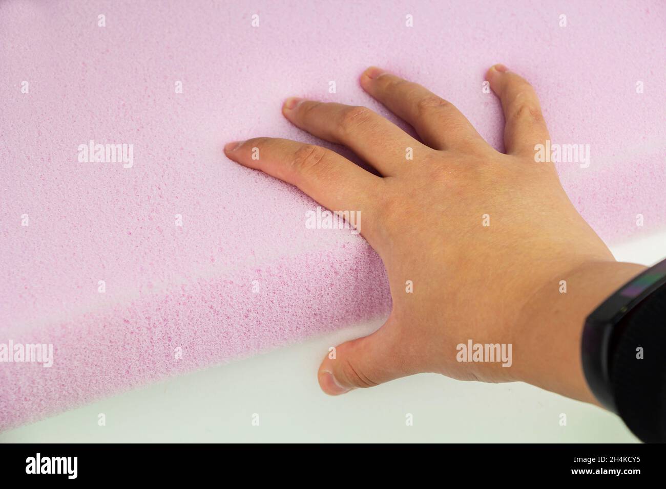 the hand presses on the surface of the rubber foam. Checking hardness ...