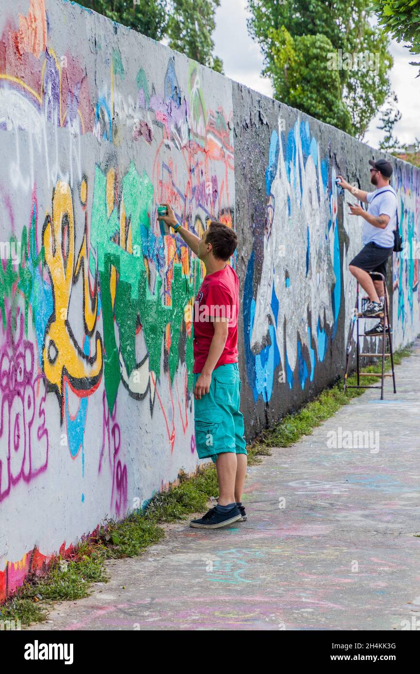BERLIN, GERMANY - AUGUST 6, 2017: Graffiti artists painting on a ...