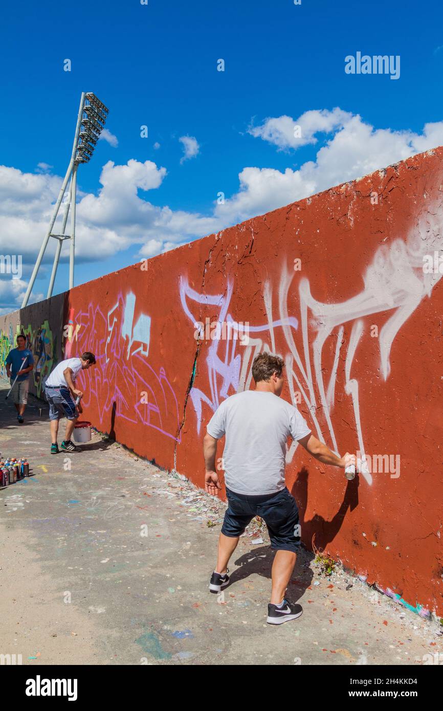 BERLIN, GERMANY - AUGUST 6, 2017: Graffiti artists painting on a ...