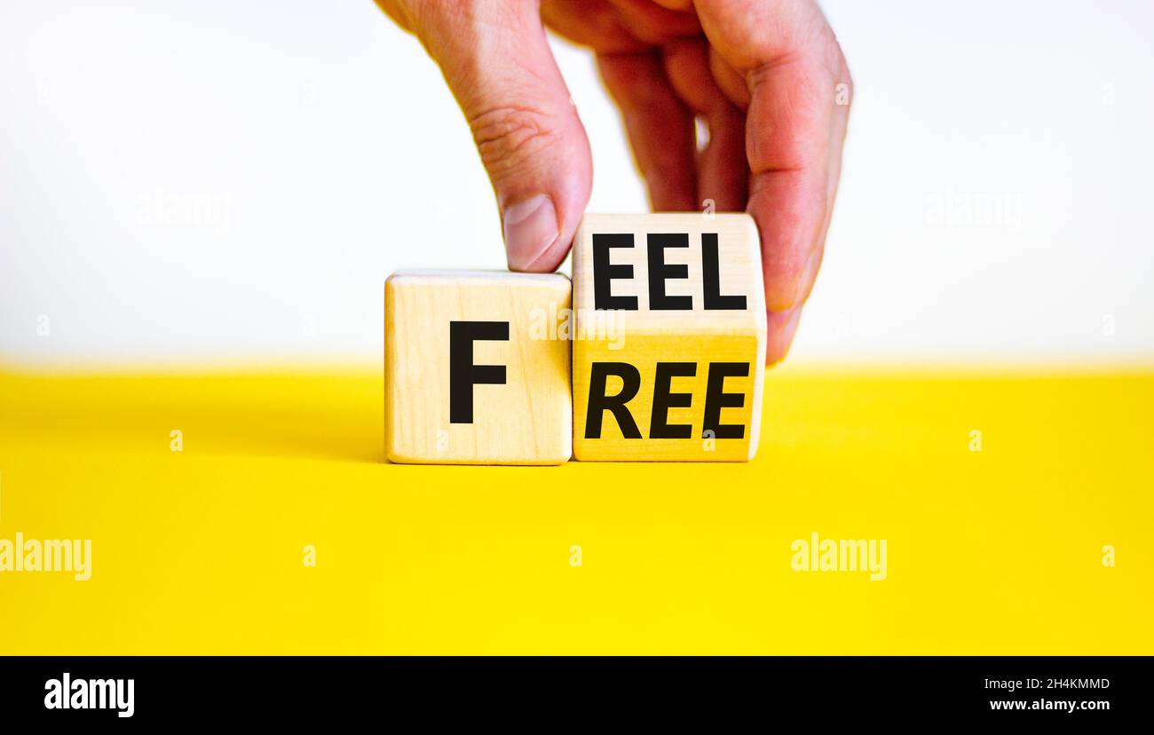 Feel free symbol. Businessman turns a wooden cube with concept words ...
