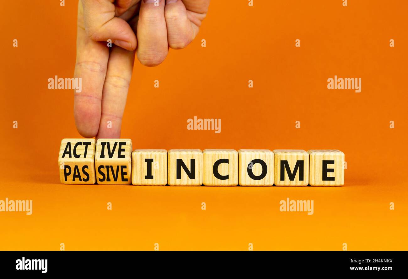 Passive or active income symbol. Businessman turns wooden cubes and ...