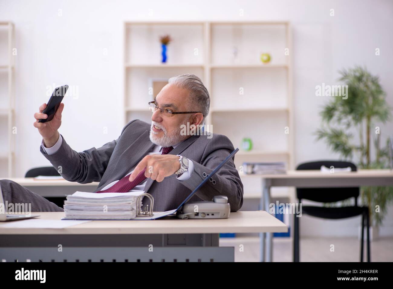 Old employee working in the office Stock Photo - Alamy