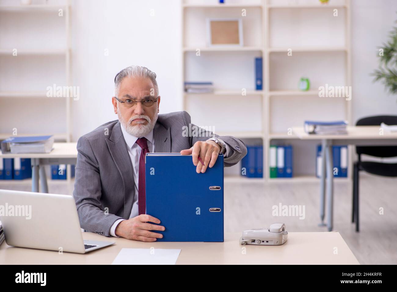 Old employee working in the office Stock Photo - Alamy